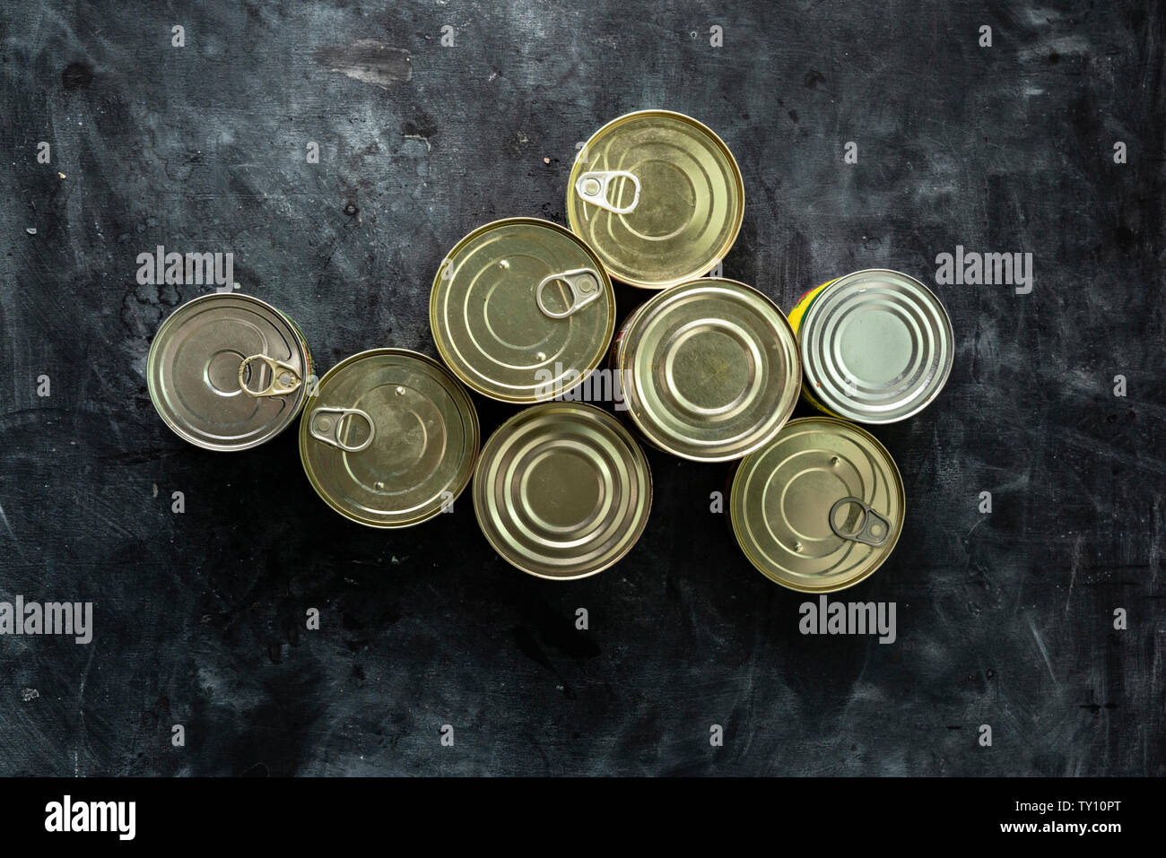 many unopened tin cans with meals such as meat and fish on the table ...
