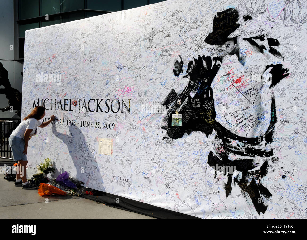 A fan signs a large poster at the Staples Center in Los Angeles on July ...
