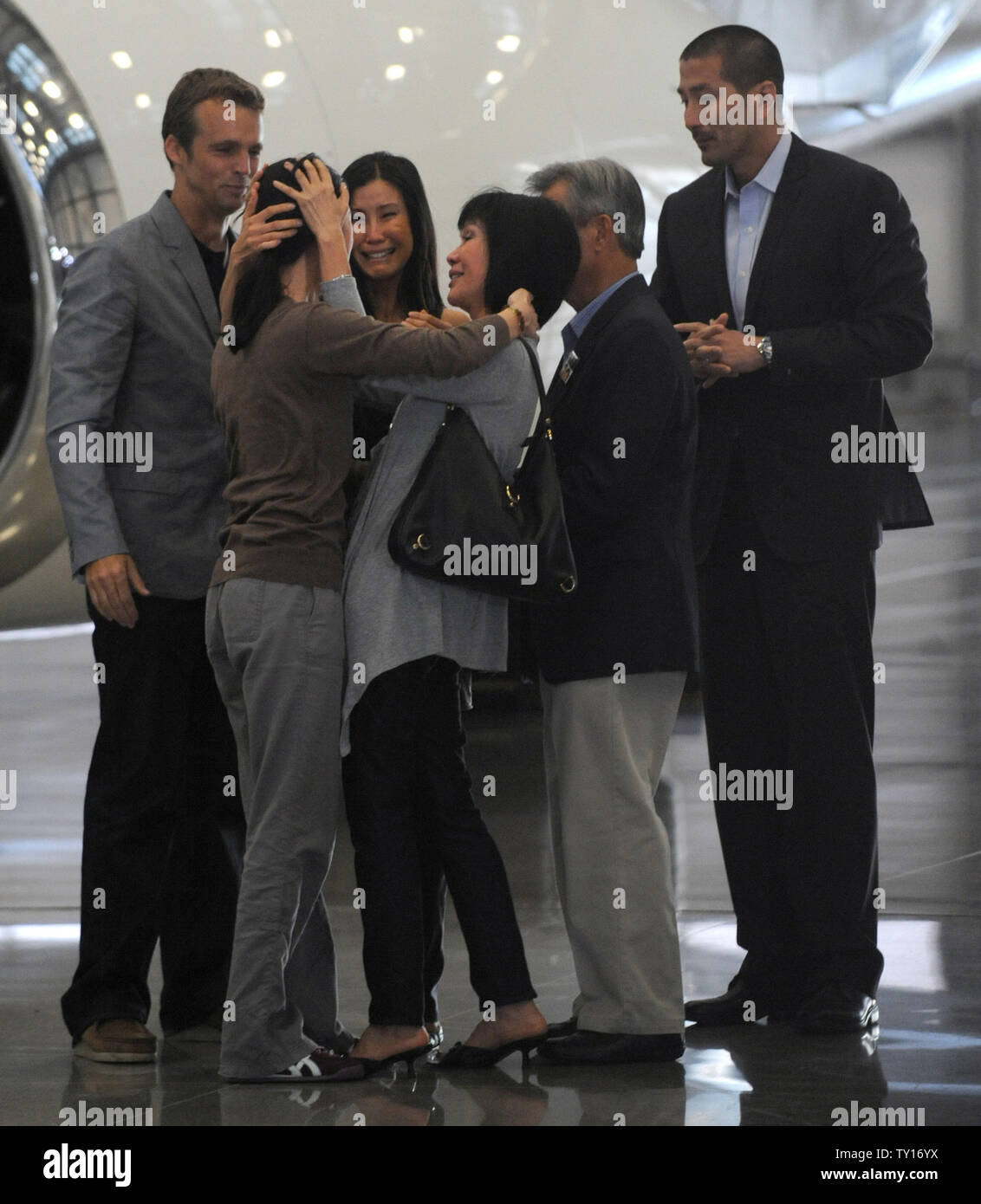 Laura Ling (L) is greeted by her mother Mary, father Michael, sister ...