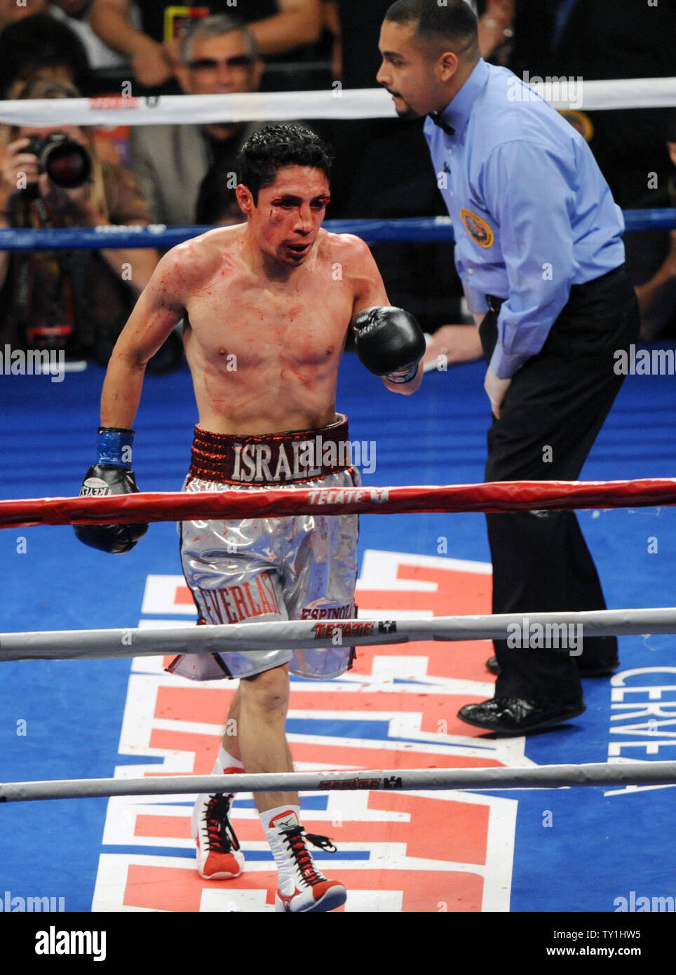 Israel Vazquez returns to his corner to be evaluated by referee Raul ...