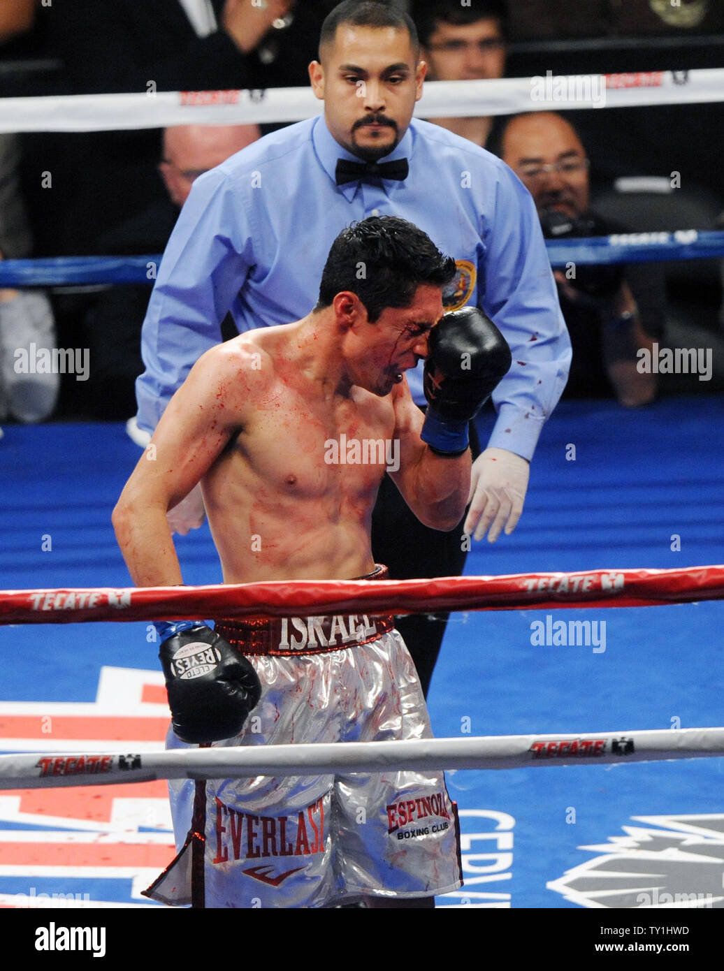 Israel Vazquez returns to his corner to be evaluated by referee Raul ...