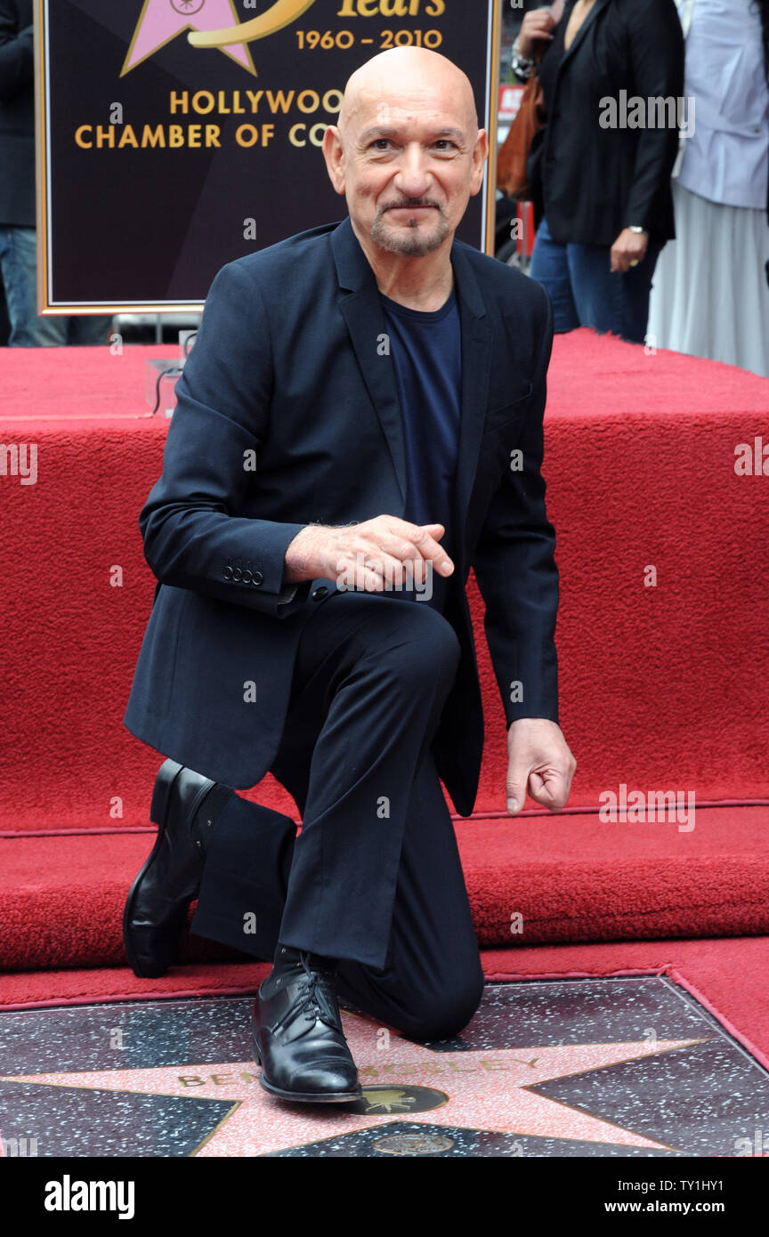 Actor Ben Kingsley kneels next to his star during an unveiling ceremony ...