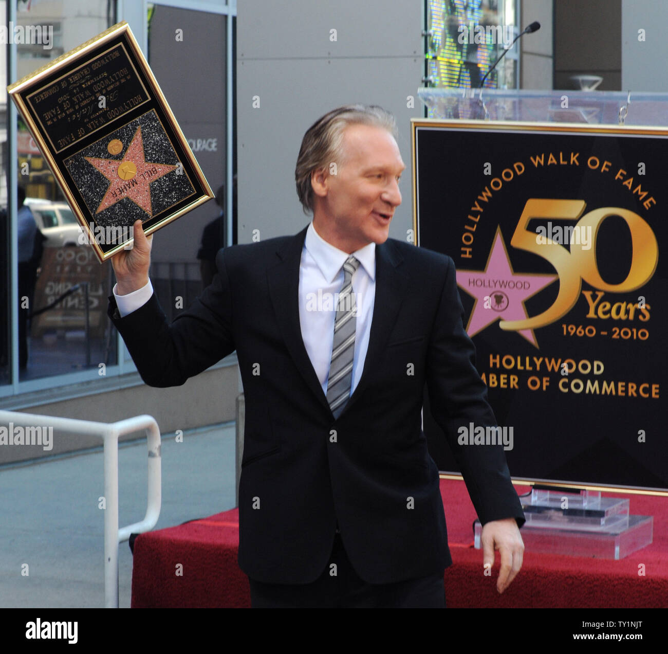 Comedian and television host Bill Maher holds up a replica plaque of ...