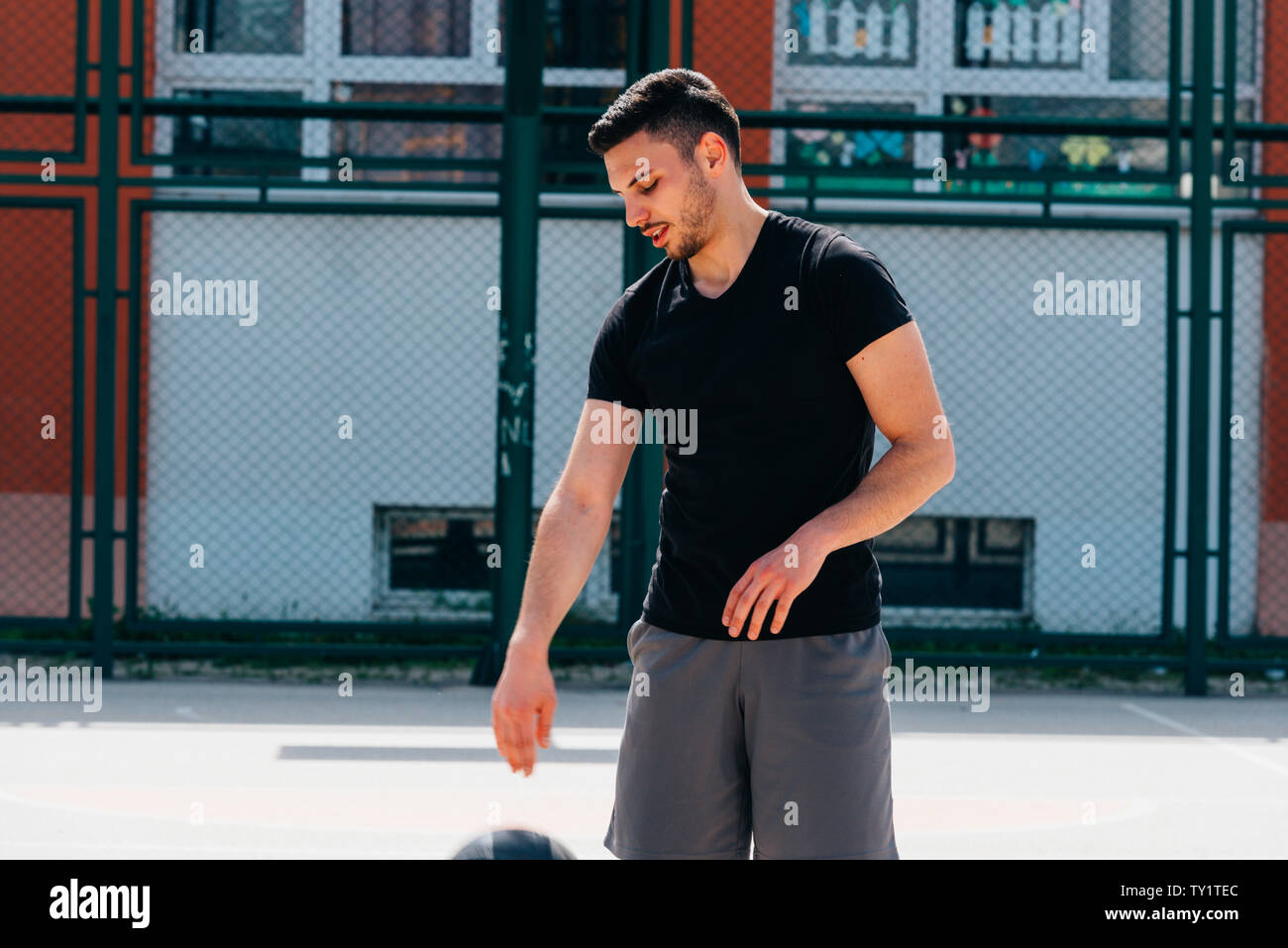 Fit male basketball player early in the morning on a sunny day at the ...