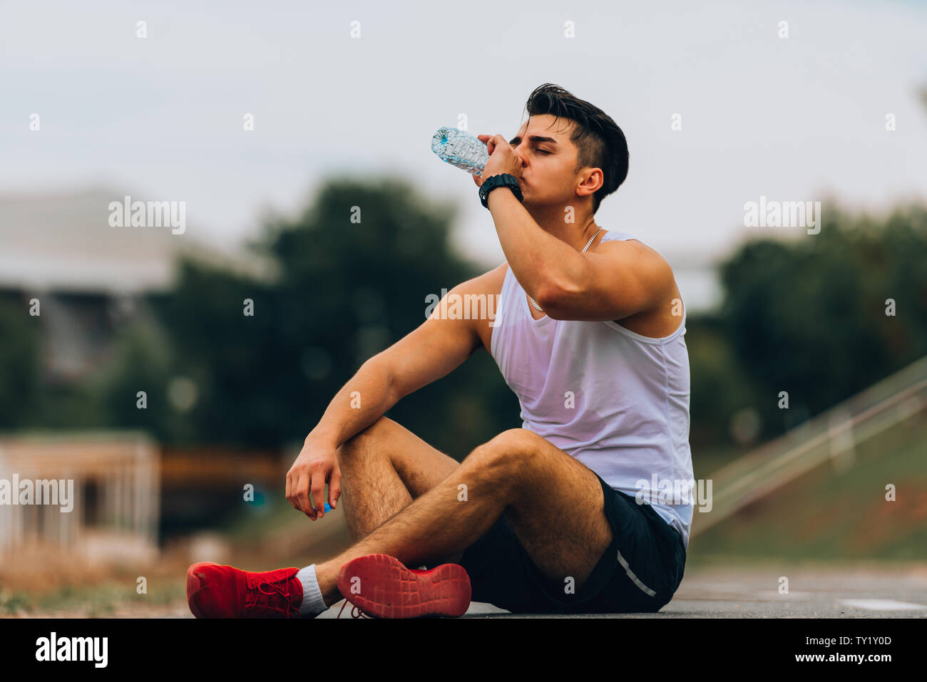 Thirsty healthy athletic male with fit body drinking refreshing drink ...