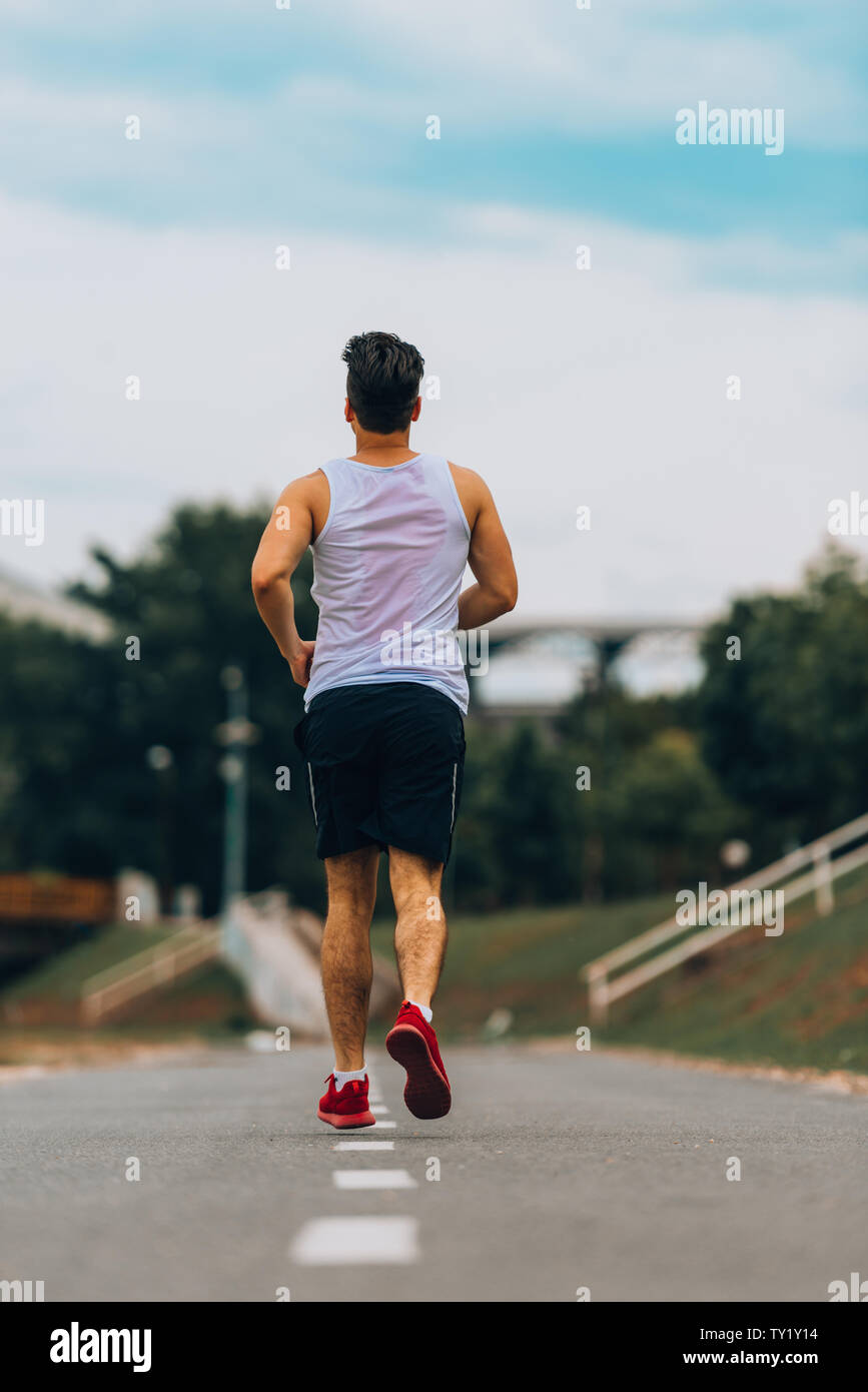 Full length portrait of an athletic young man running and working out ...