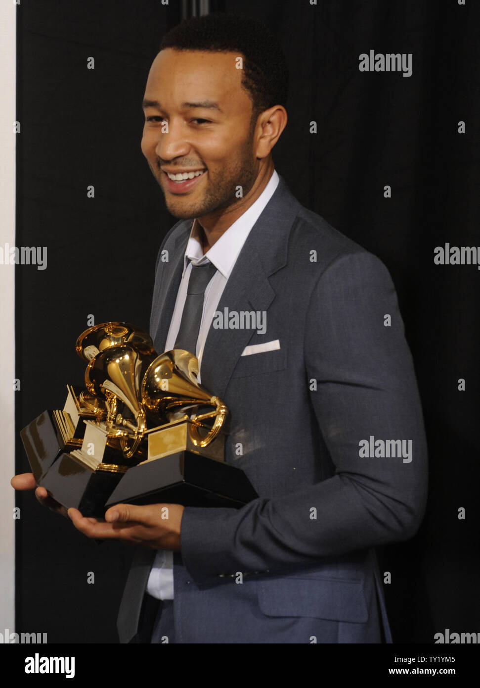John Legend appears backstage with the three Grammy Awards he won at ...