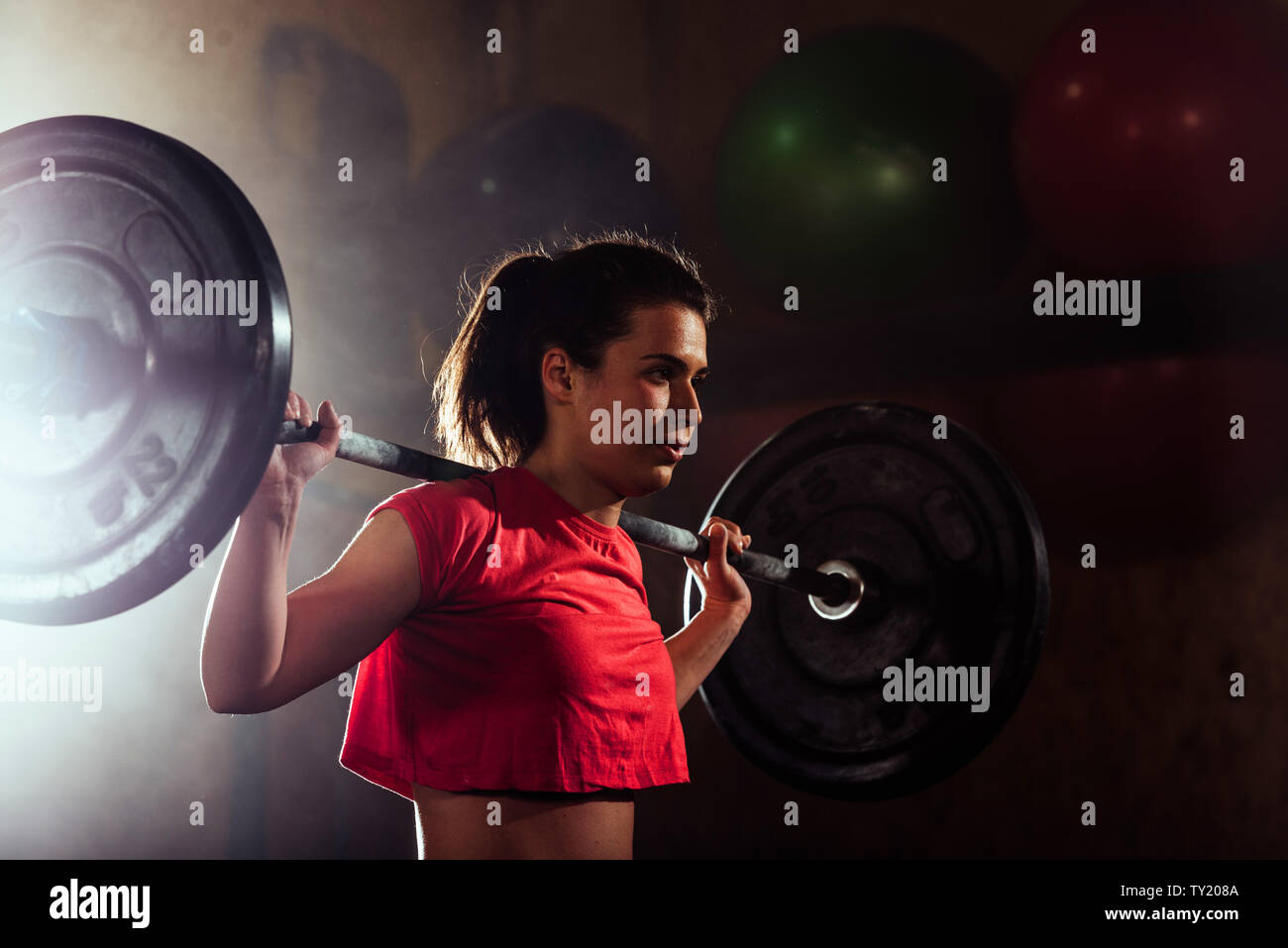 Strong woman lifting weights as a part of crossfit exercise routine ...