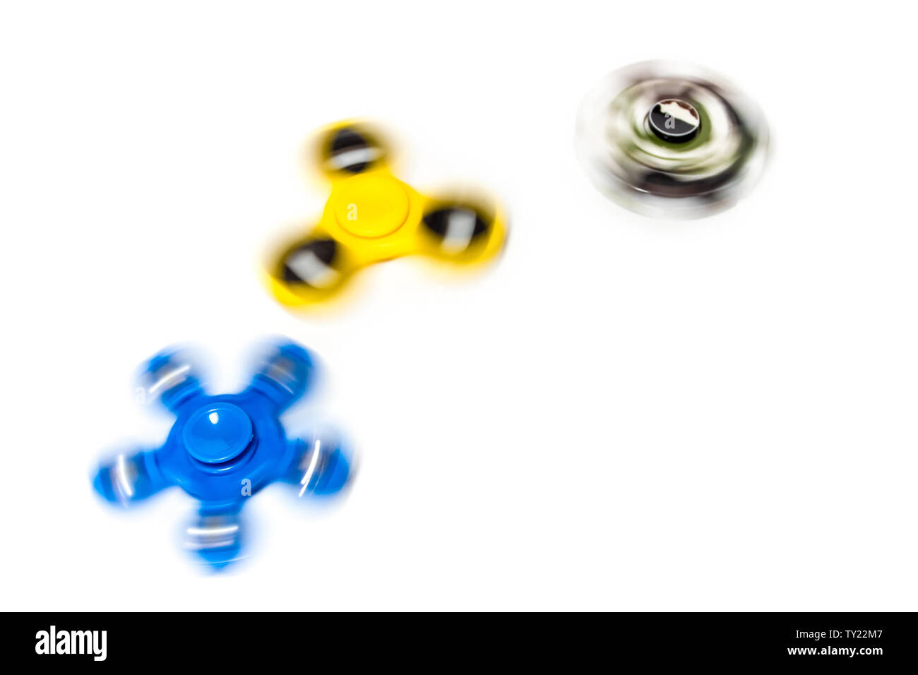 fidget hand spinner spinning on white background Stock Photo - Alamy