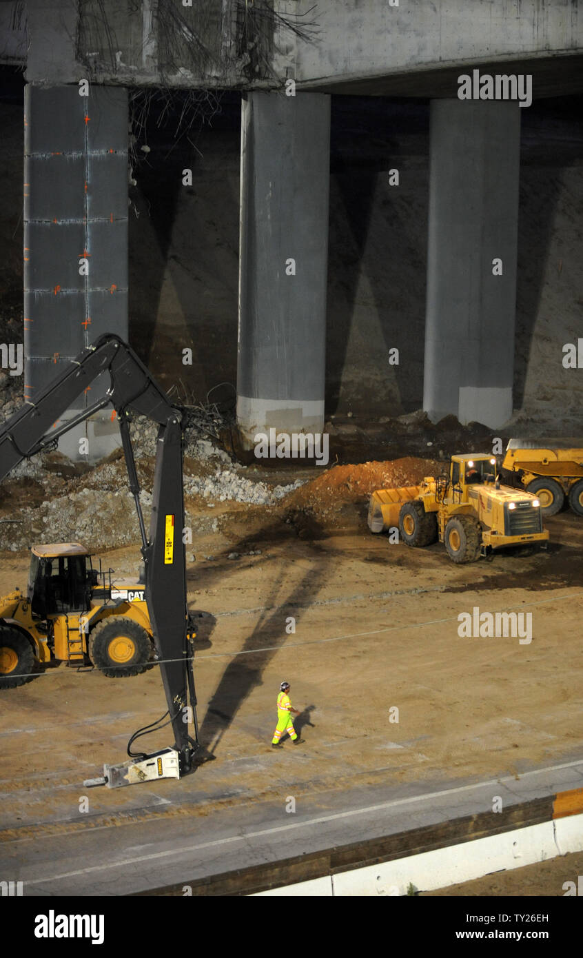 Construction workers using heavy machinary continue to demolish the ...