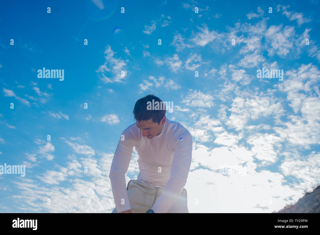 Bodybuilder performing his stretching routine in the morning on an ...