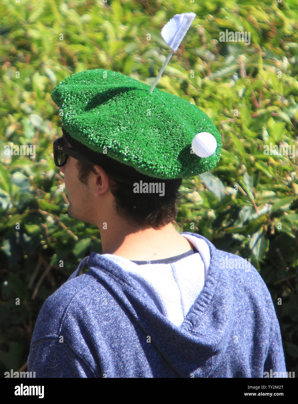 A fan wears a putting green beret during the first day of play at the ...