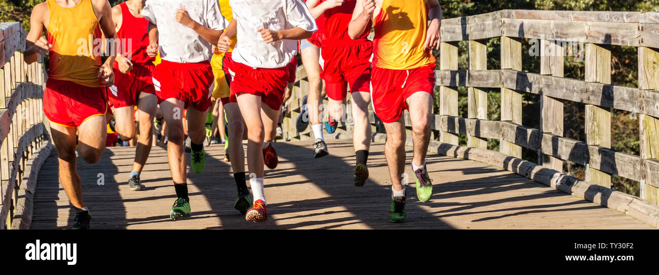 The leaders of a high school boys cross country race crossing over the ...