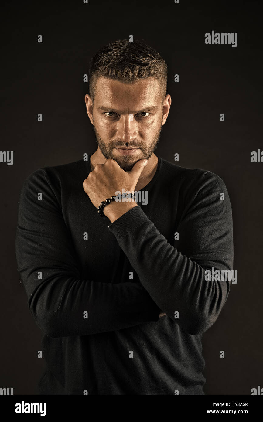Man with evil look isolated on dark background. Macho touching his ...