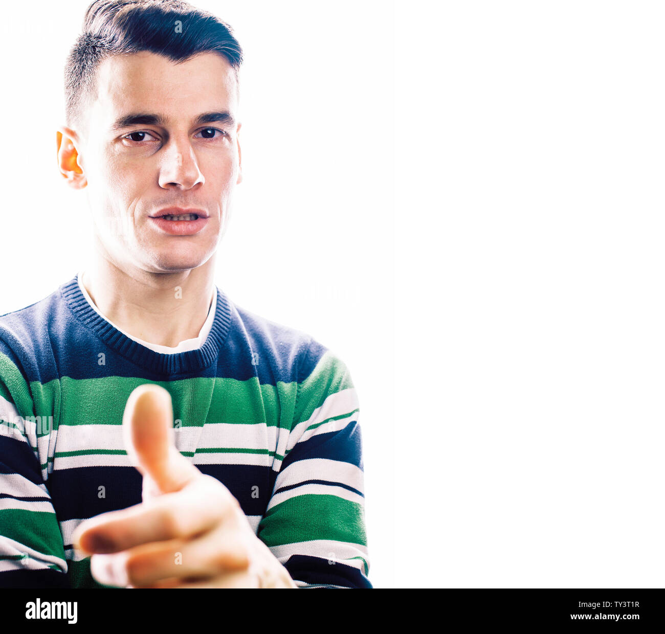 Portrait of a smart serious young man standing against white background ...