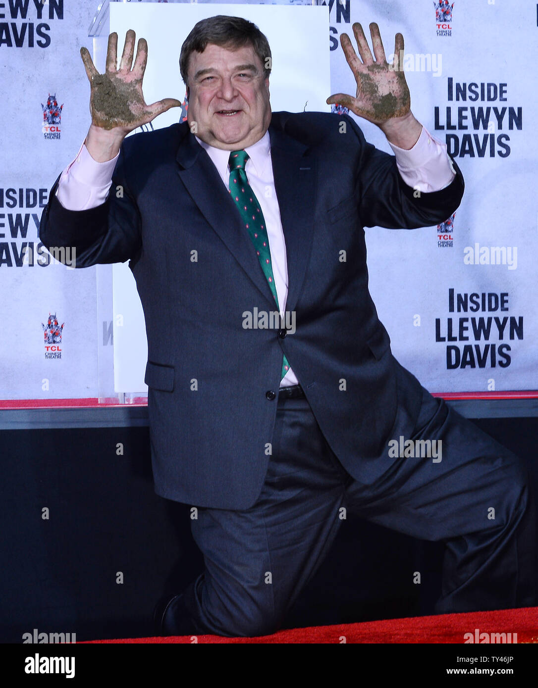 Actor John Goodman raises his hands after placing them in wet cement ...