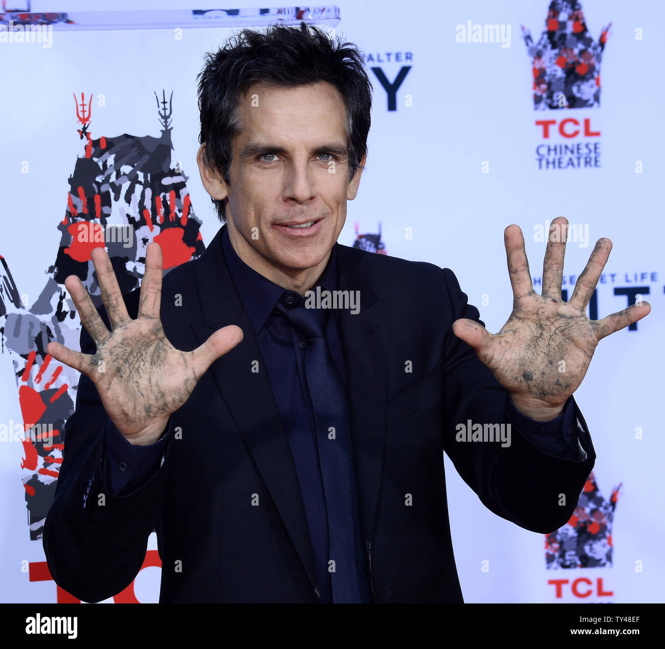 Actor Ben Stiller holds up his hands after placing them in wet cement ...