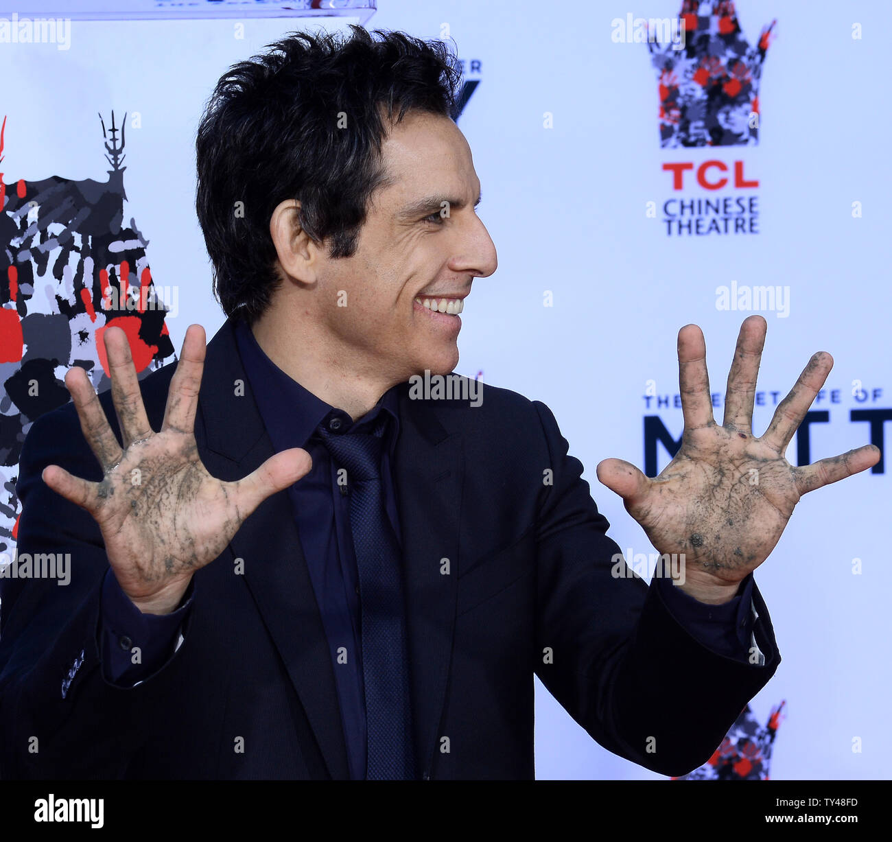 Actor Ben Stiller holds up his hands after placing them in wet cement ...