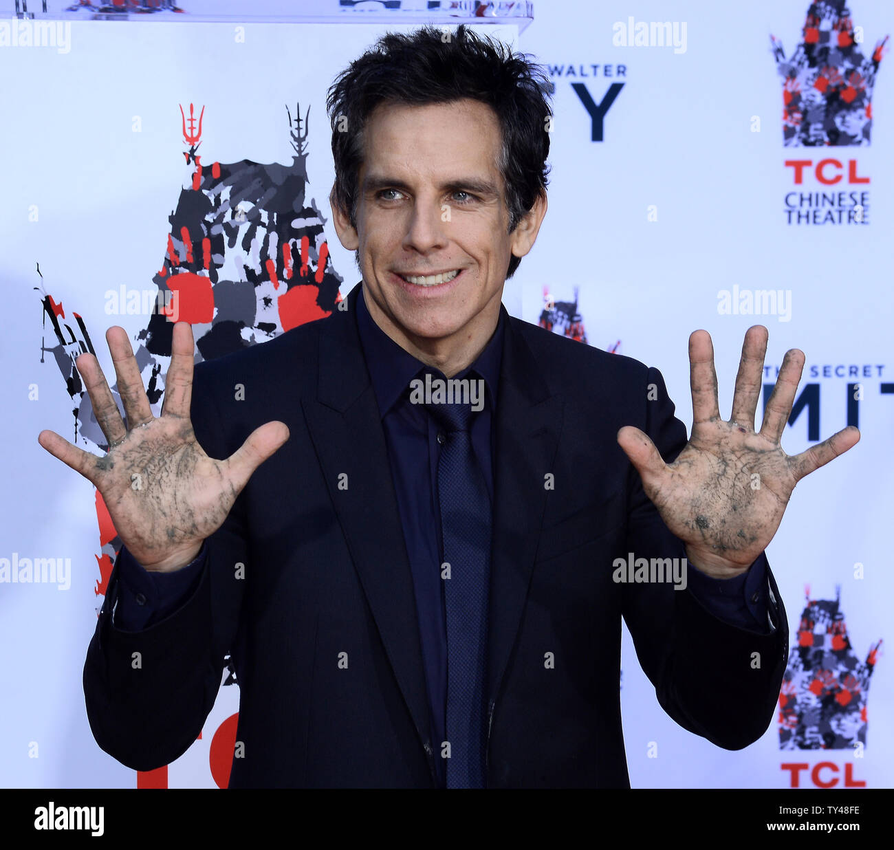 Actor Ben Stiller holds up his hands after placing them in wet cement ...