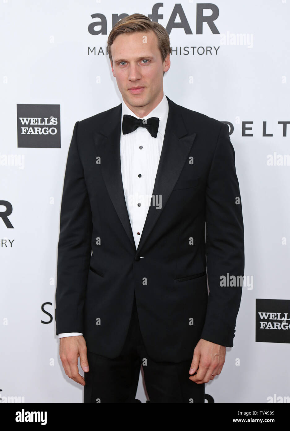 Teddy Sears arrives on the red carpet during the 2013 amfAR Inspiration ...