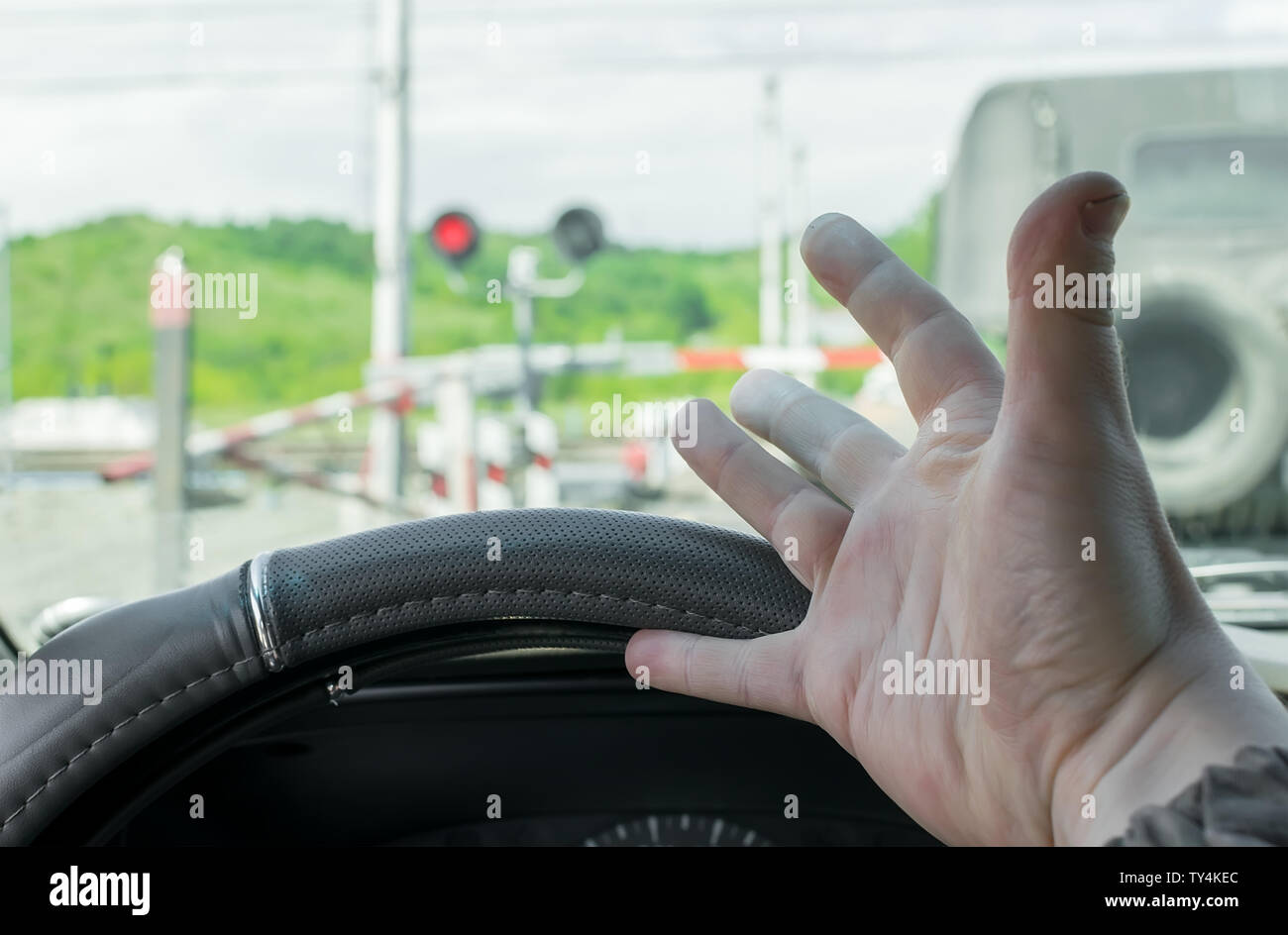 The hand of man inside the car. The car stopped in front of a closed ...