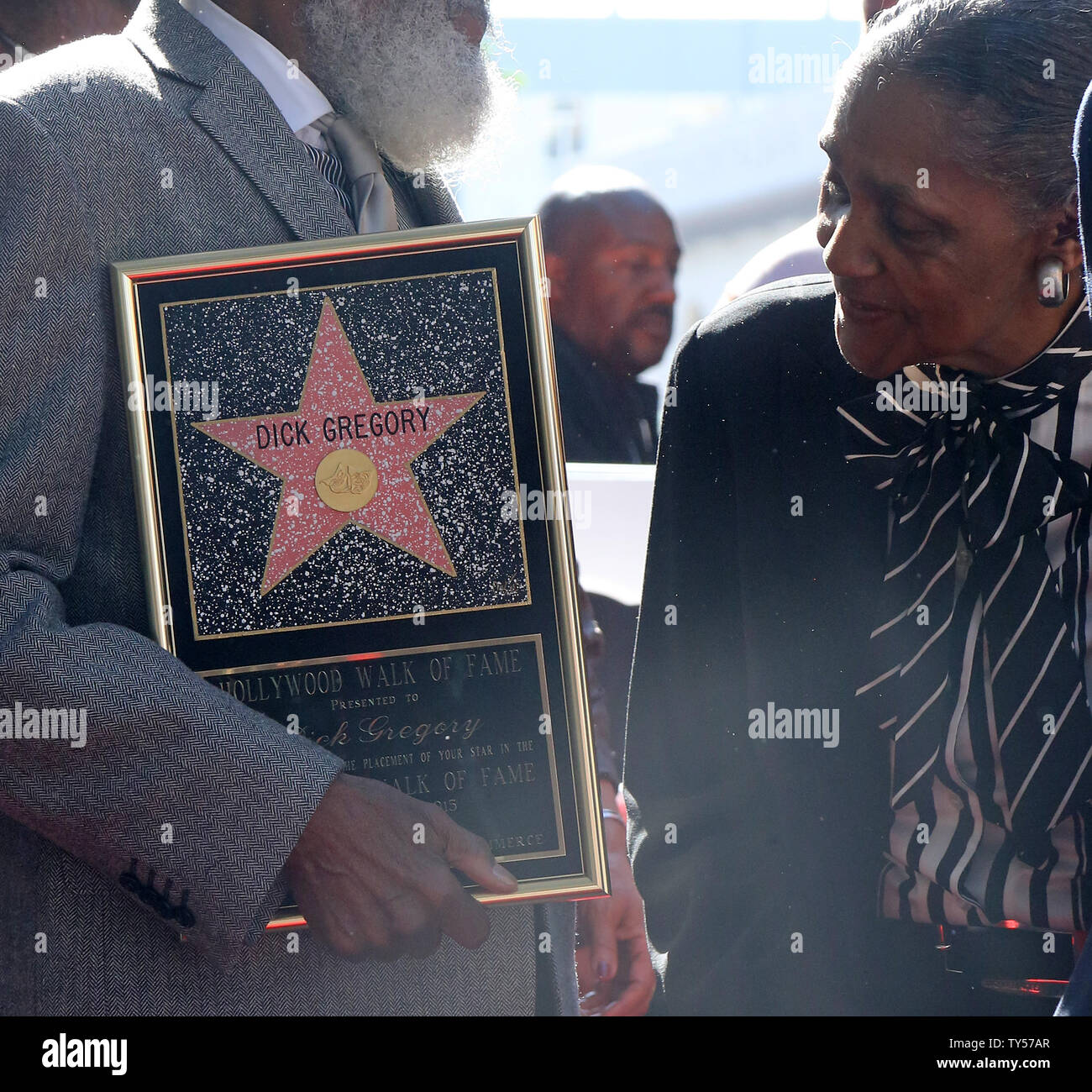 Dick Gregory holds a replica plaque next to his wife Lillian during an ...