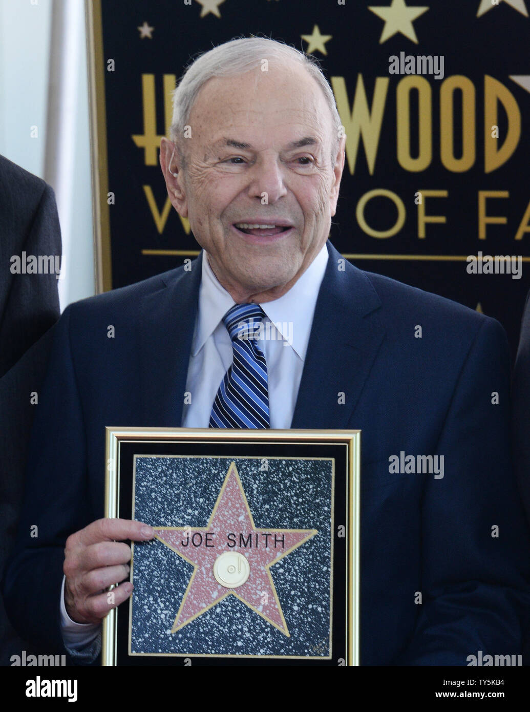 Music executive and producer Joe Smith holds a replica plaque during an ...