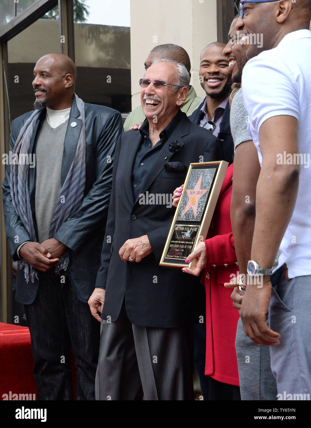 Clippers sportscaster Ralph Lawler holds a replica plaque as he is ...