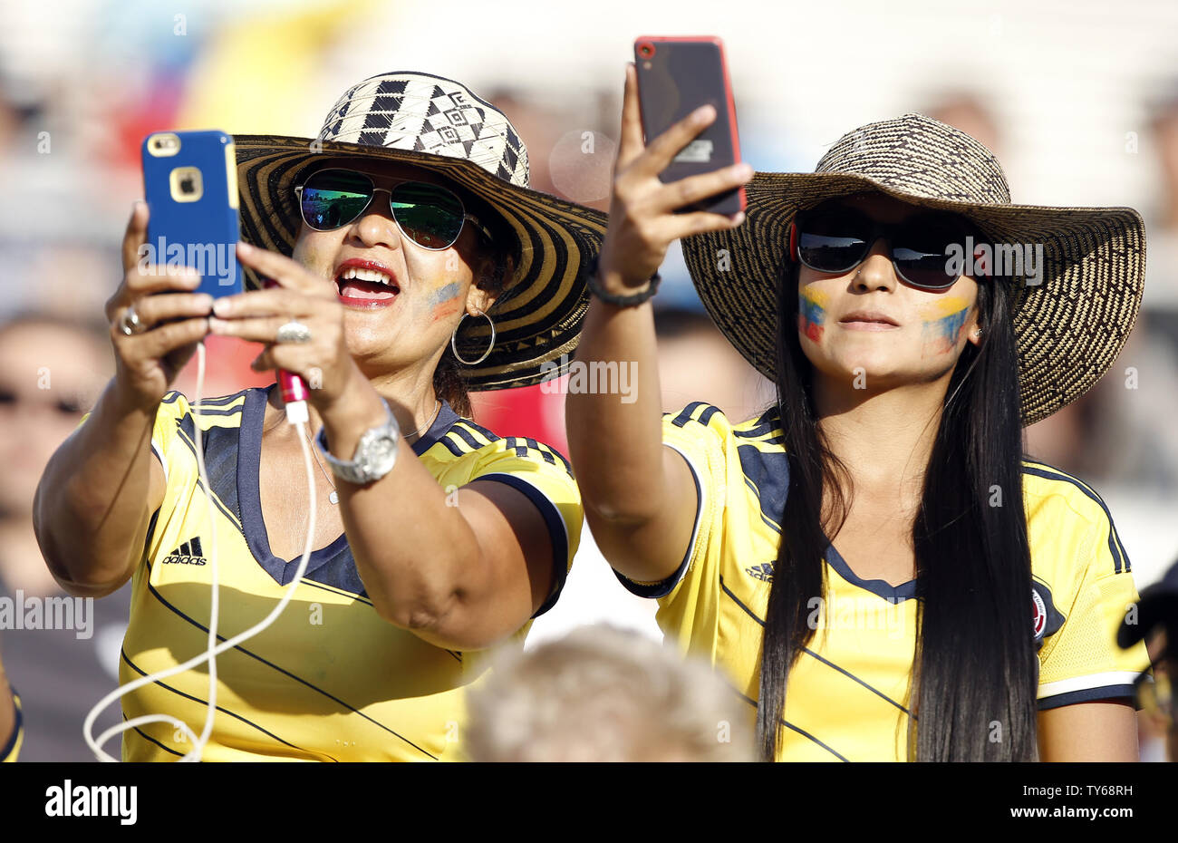 Colombian fans take photos as their team enters the pitch to play ...