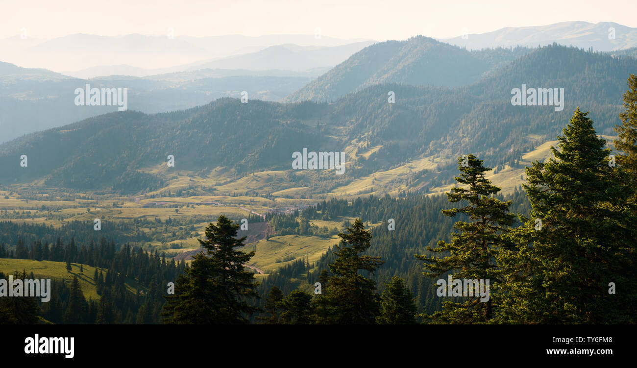 Country road stretching to the horizon between mountain ranges ...