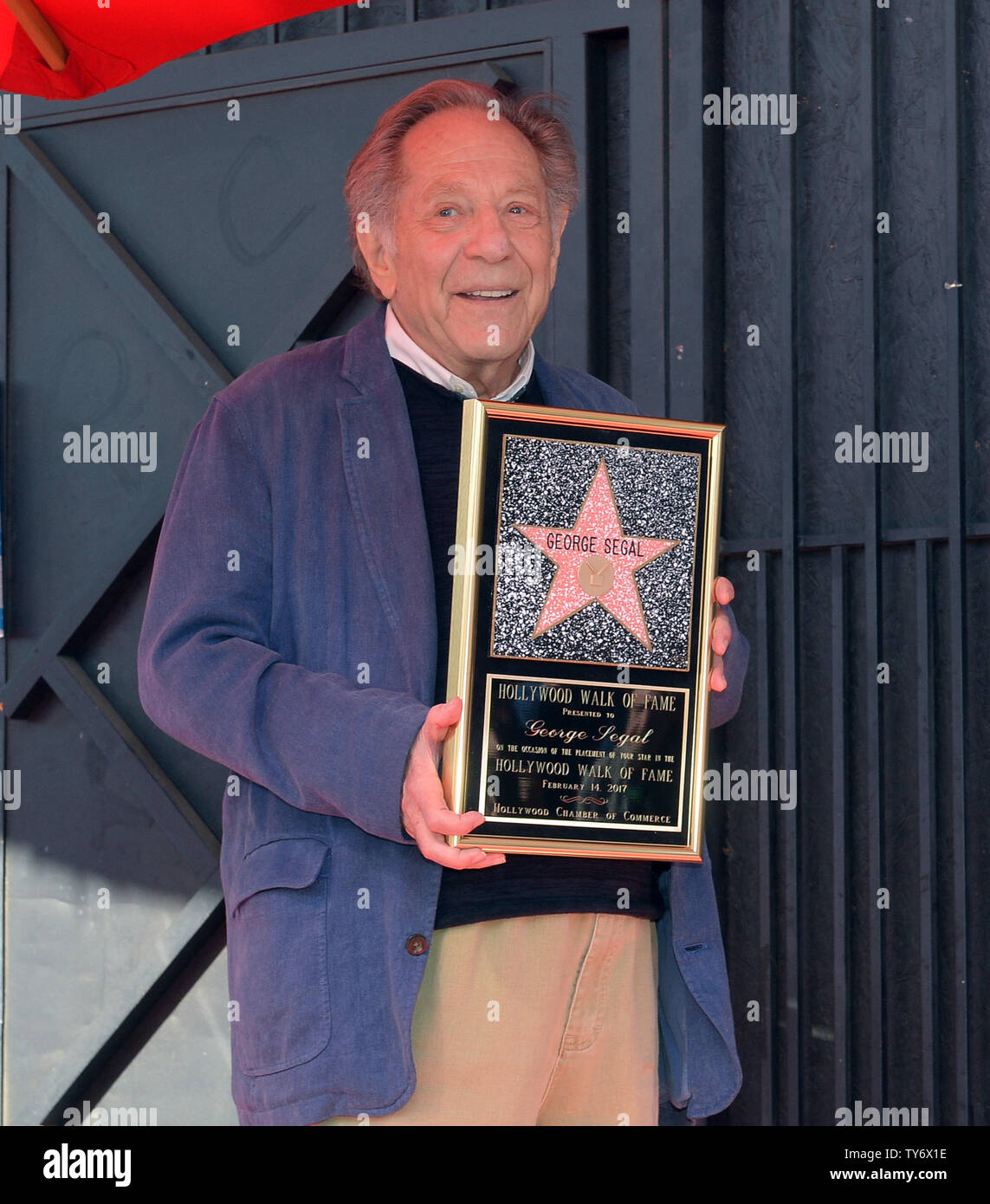 Actor George Segal holds a replica plaque during a ceremony honoring ...