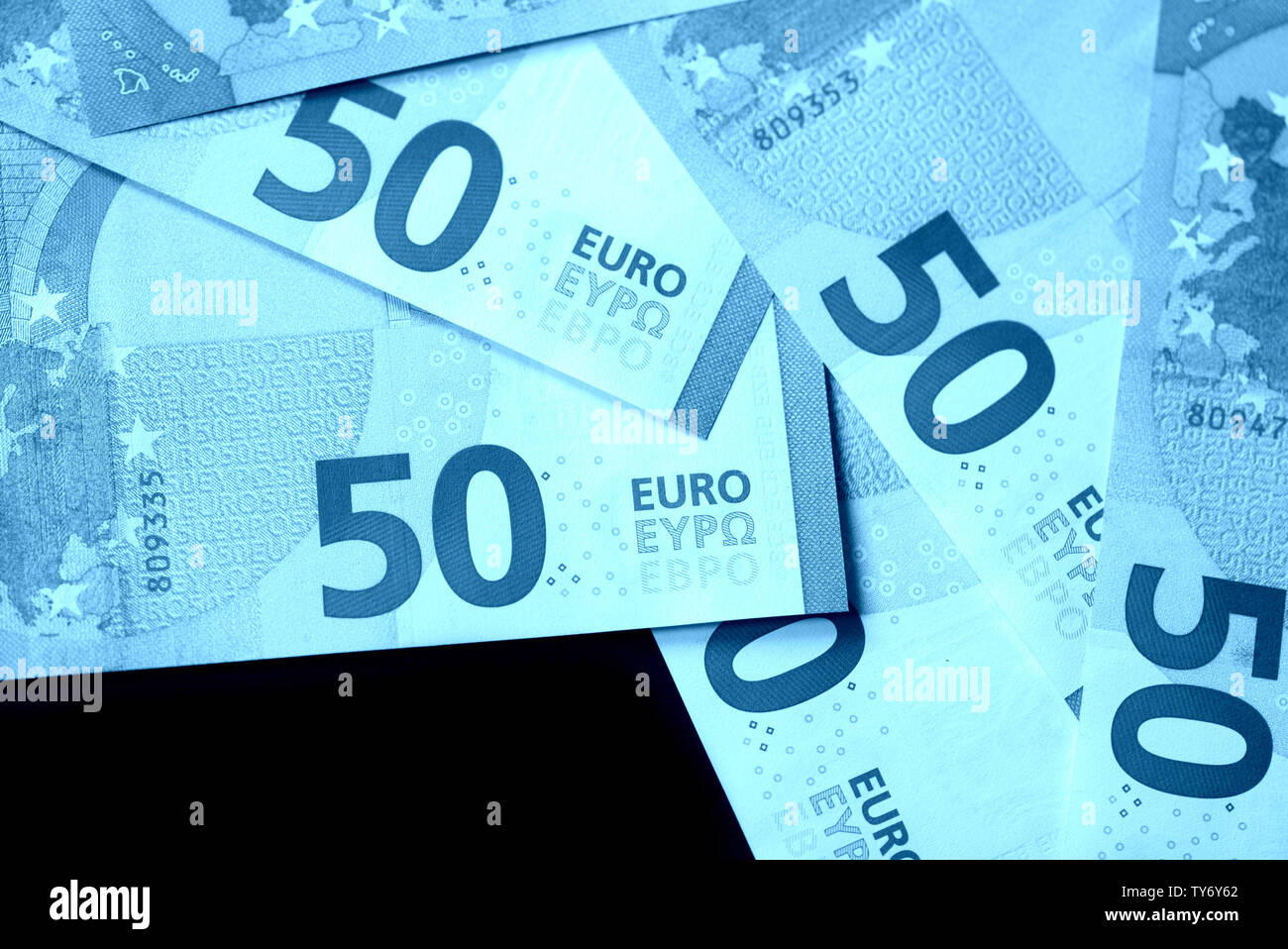 Fifty euro notes on a dark background close up. Blue color toned Stock ...
