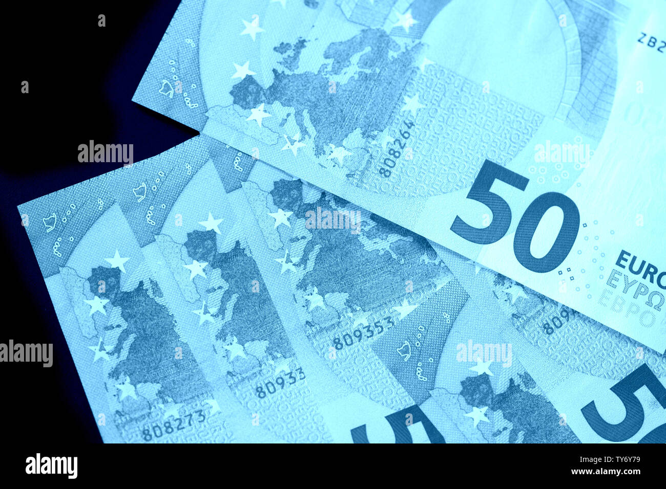 Fifty euro notes on a dark background close up. Blue color toned Stock ...