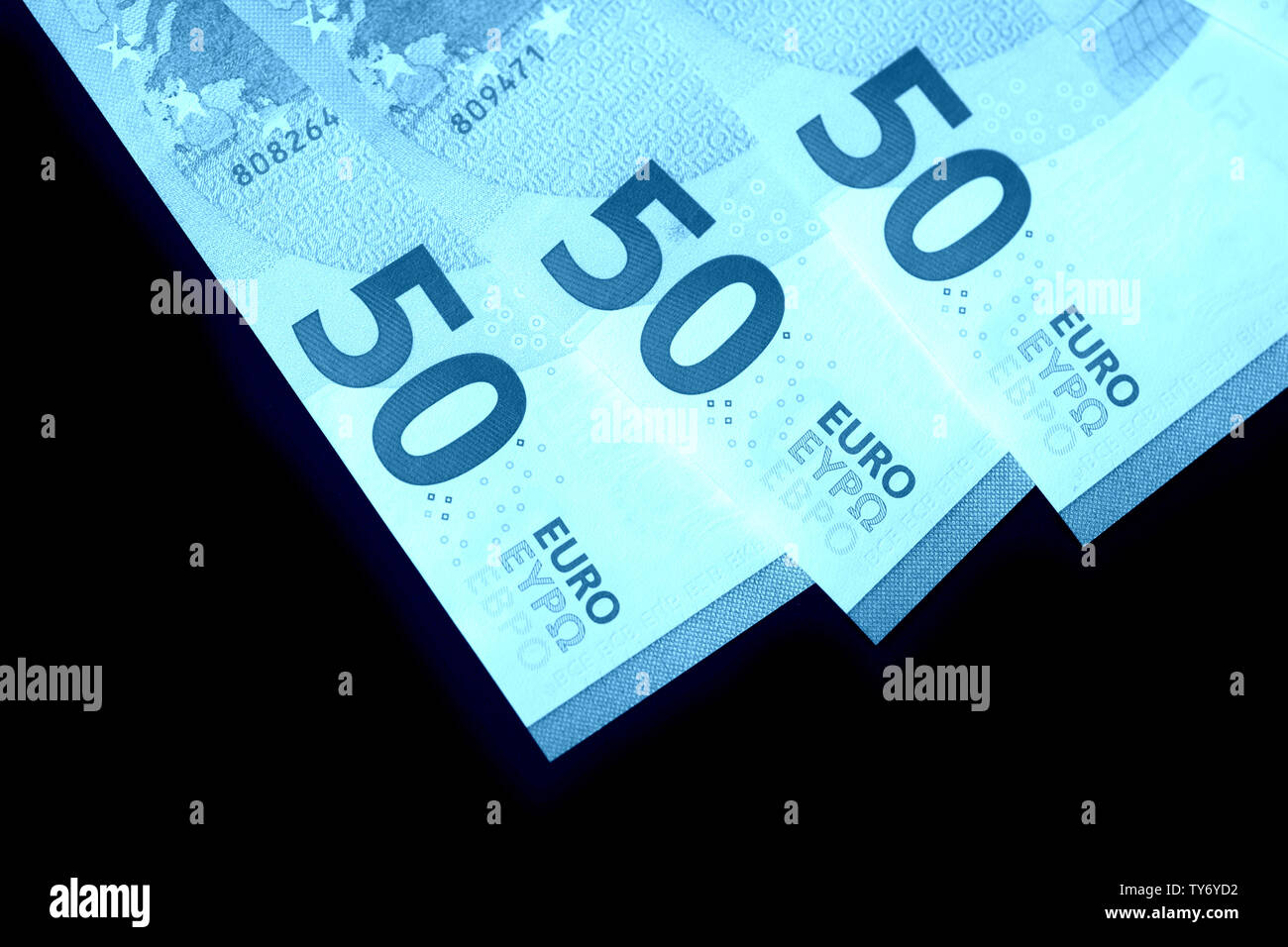 Fifty euro notes on a dark background close up. Blue color toned Stock ...