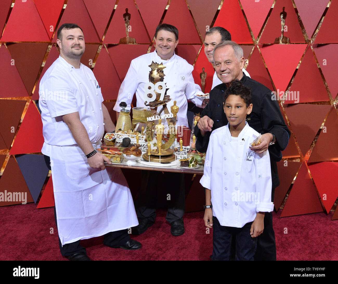 Chef Wolfgang Puck (2nd R) arrives on the red carpet for the 89th ...