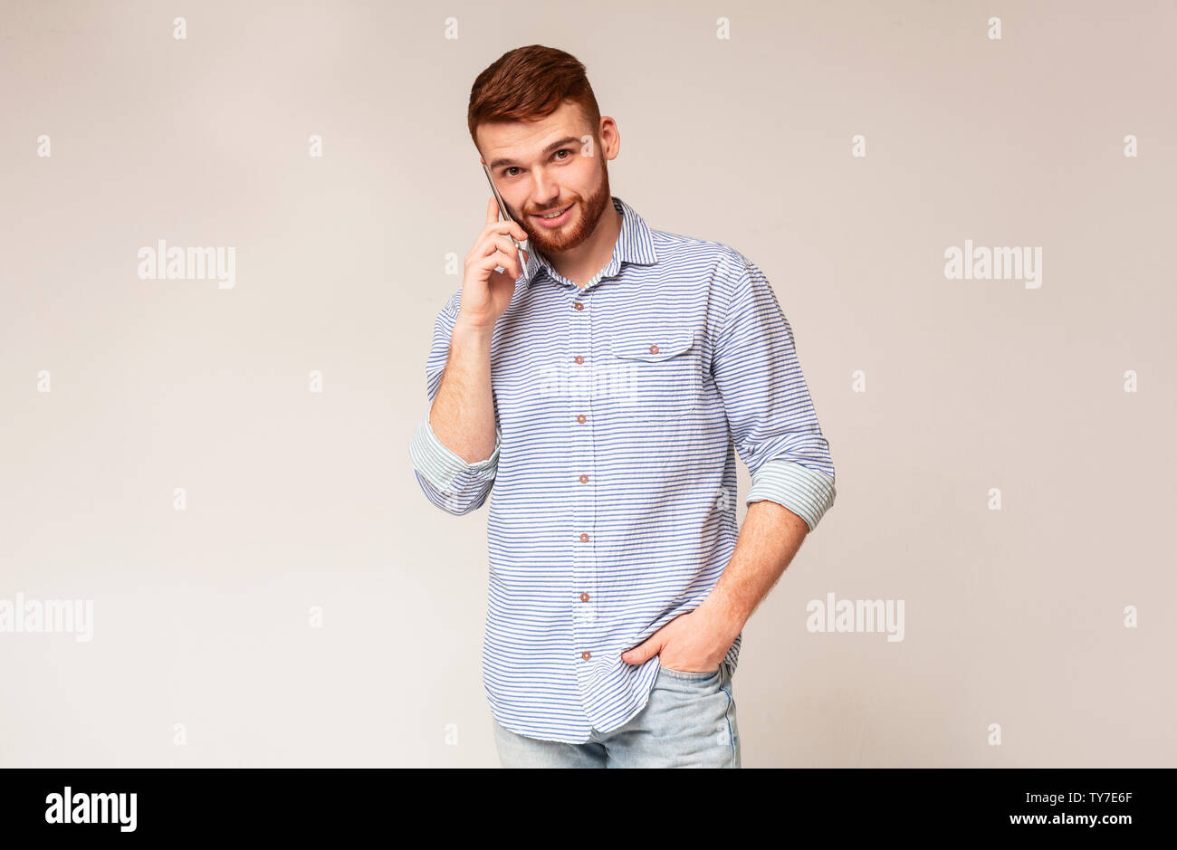 Portrait of smiling man talking on phone on studio background Stock ...
