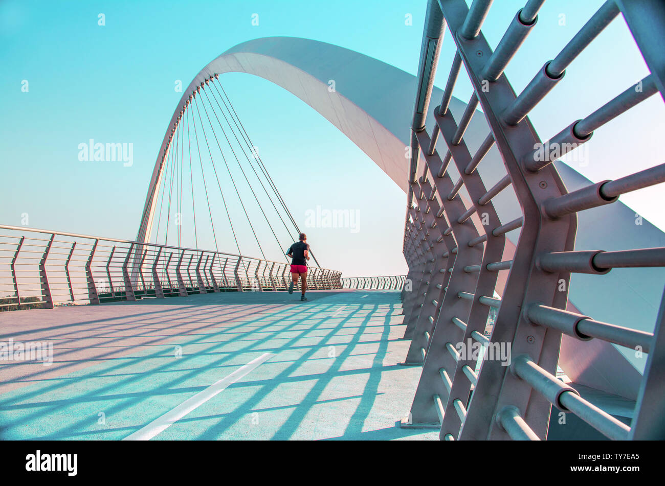 Dubai Water canal Tolerance Bridge young man running on the bridge ...