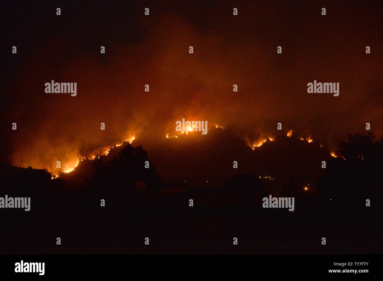 Smoke reflecting the orange light of flames from the Thompson fire can ...