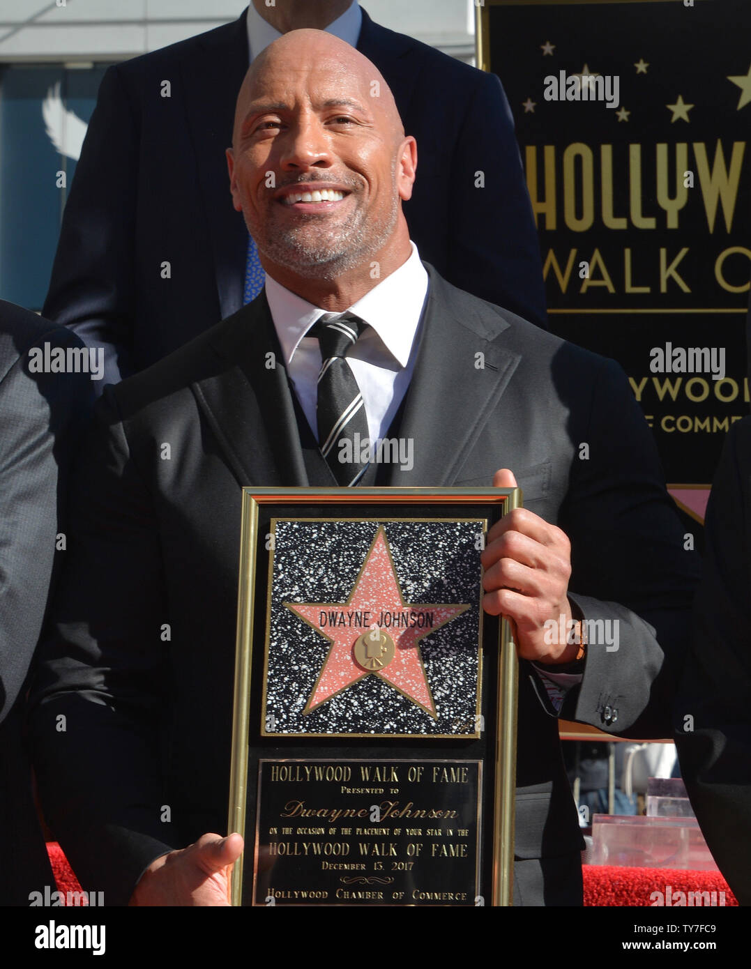 Actor Dwayne Johnson, aka "The Rock" holds a replica plaque during an ...