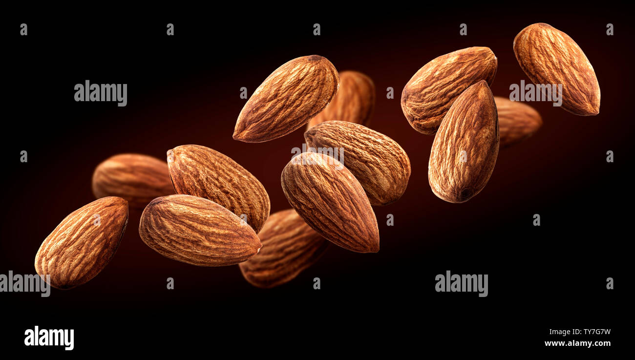 Flying almond isolated on black background Stock Photo - Alamy