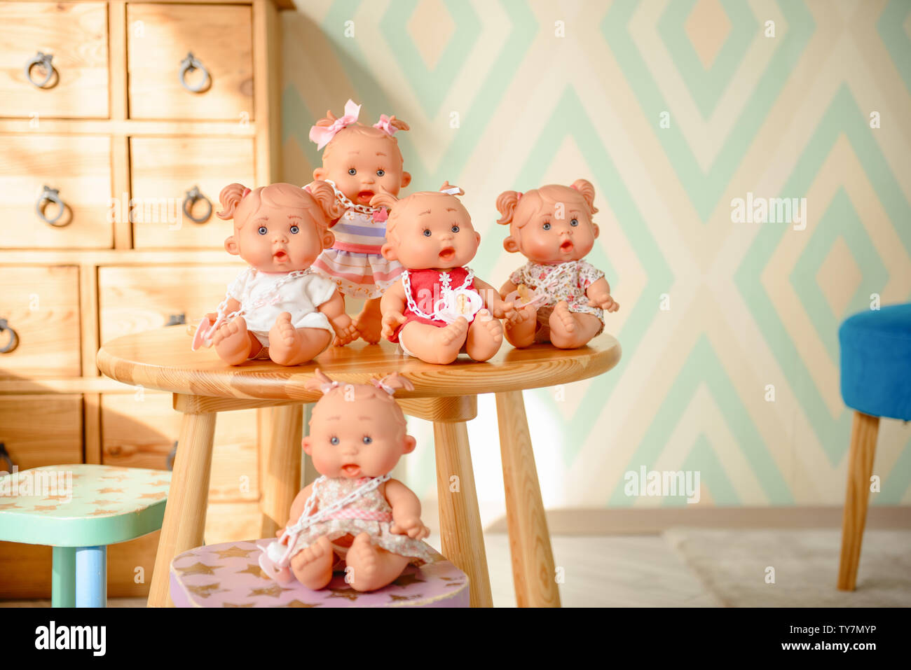 Group of cute baby dolls on the table on bright background Stock Photo ...
