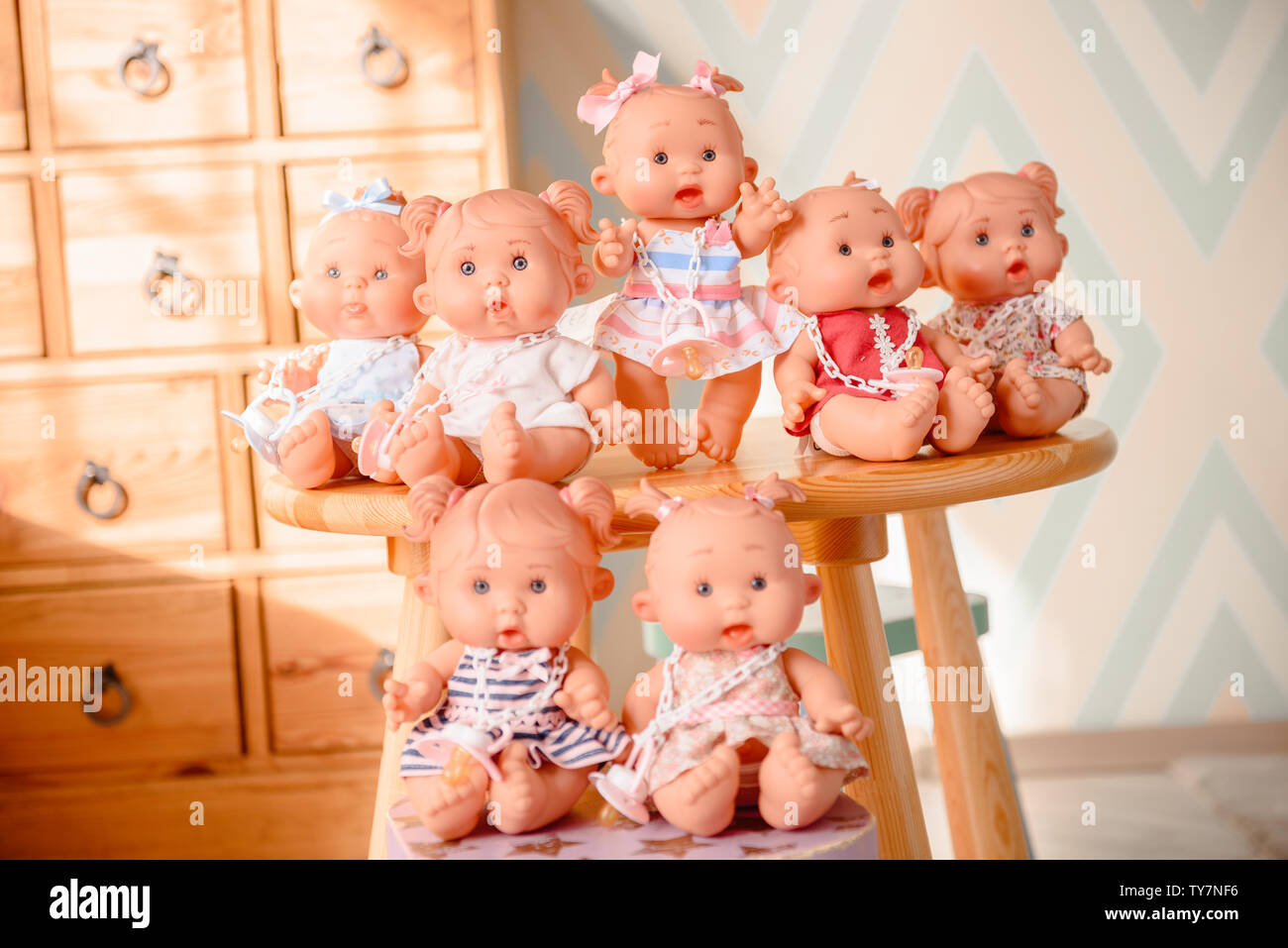 Group of cute baby dolls on the table on bright background Stock Photo ...