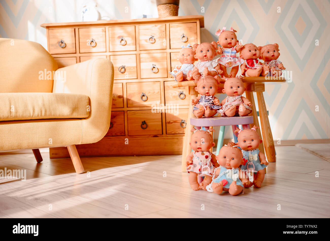 Group of cute baby dolls on the table on bright background Stock Photo ...