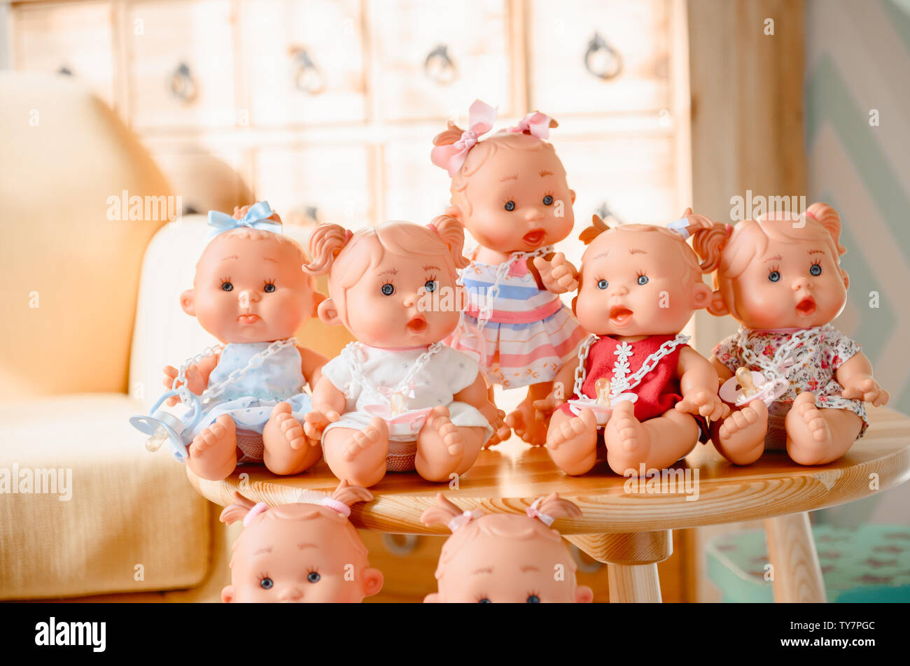 Group of cute baby dolls on the table on bright background Stock Photo ...