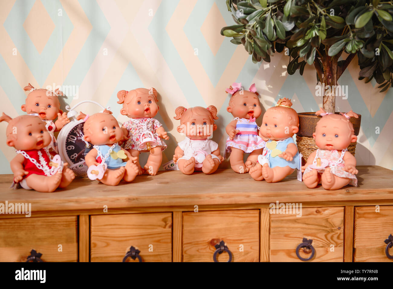 Group of cute baby dolls on the table on bright background Stock Photo ...