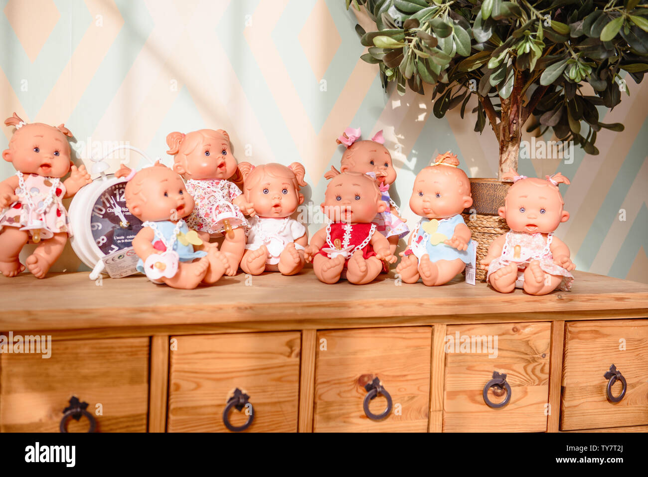 Group of cute baby dolls on the table on bright background Stock Photo ...