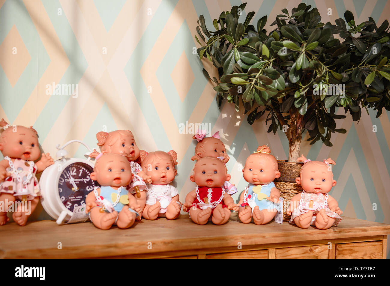 Group of cute baby dolls on the table on bright background Stock Photo ...