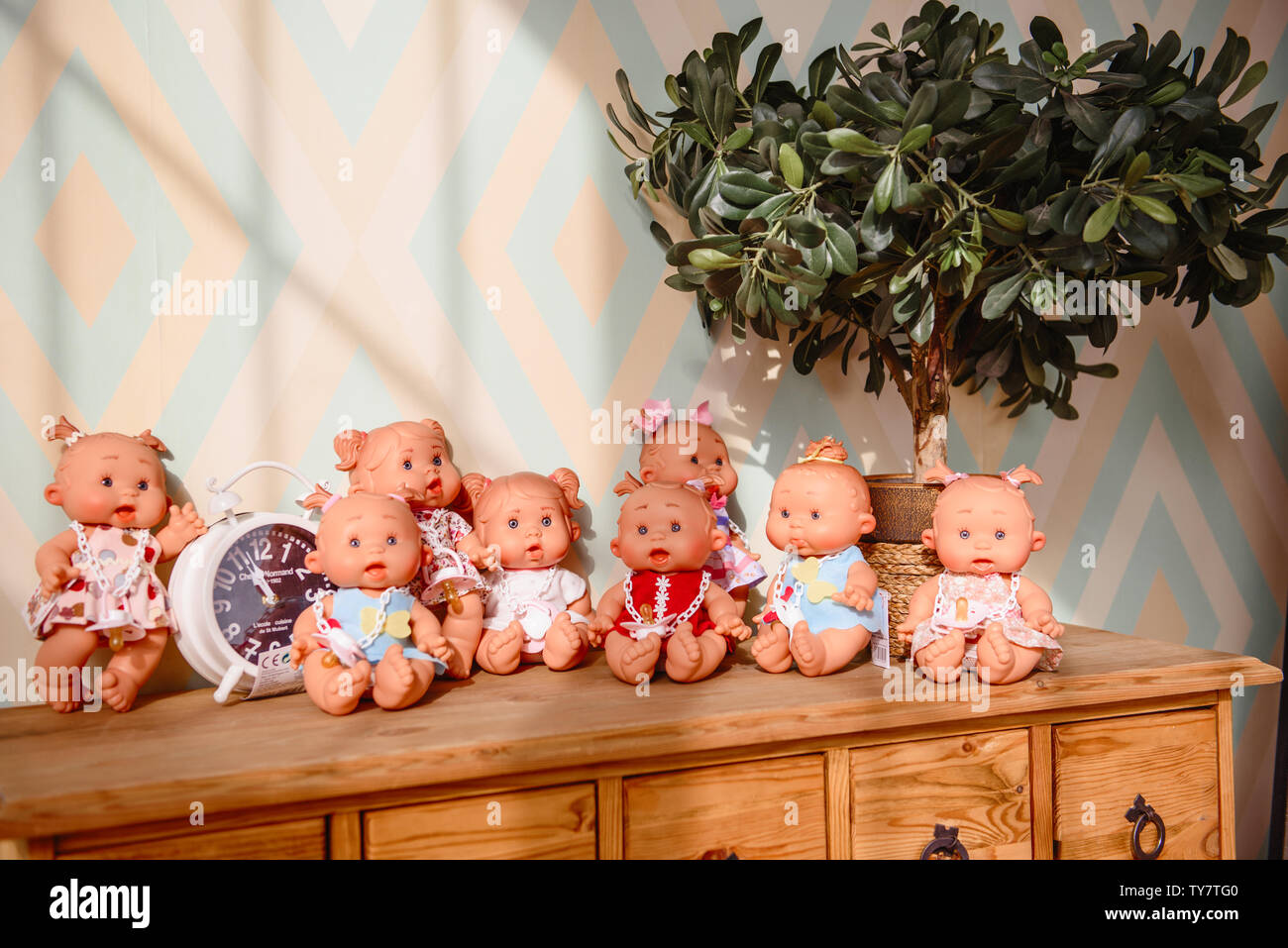 Group of cute baby dolls on the table on bright background Stock Photo ...