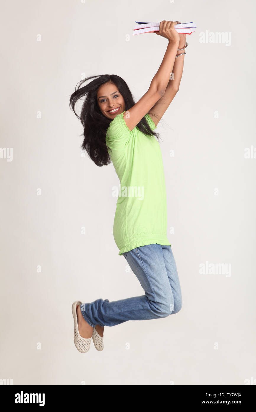 College student jumping in air and smiling Stock Photo - Alamy