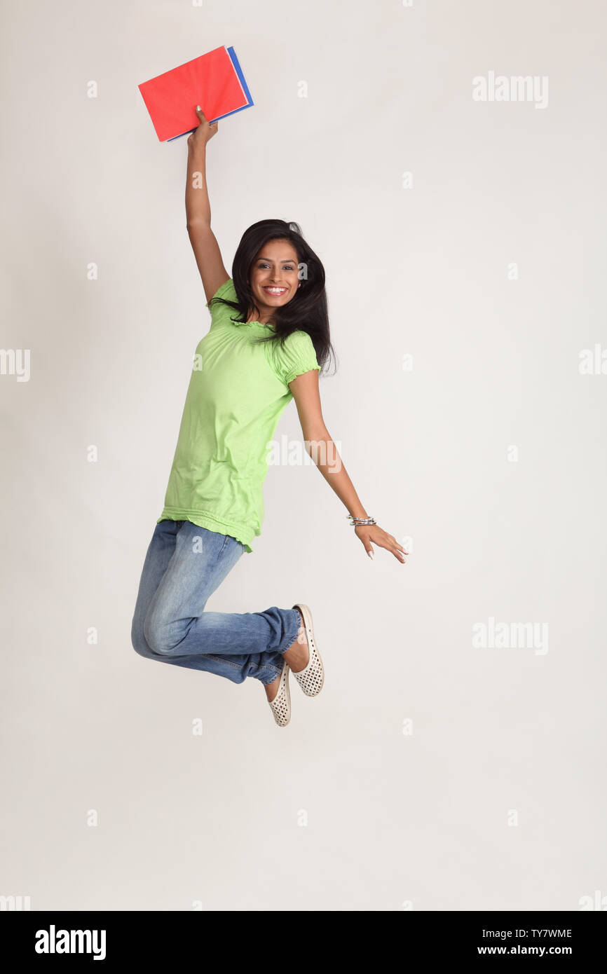 College student jumping in air and smiling Stock Photo - Alamy